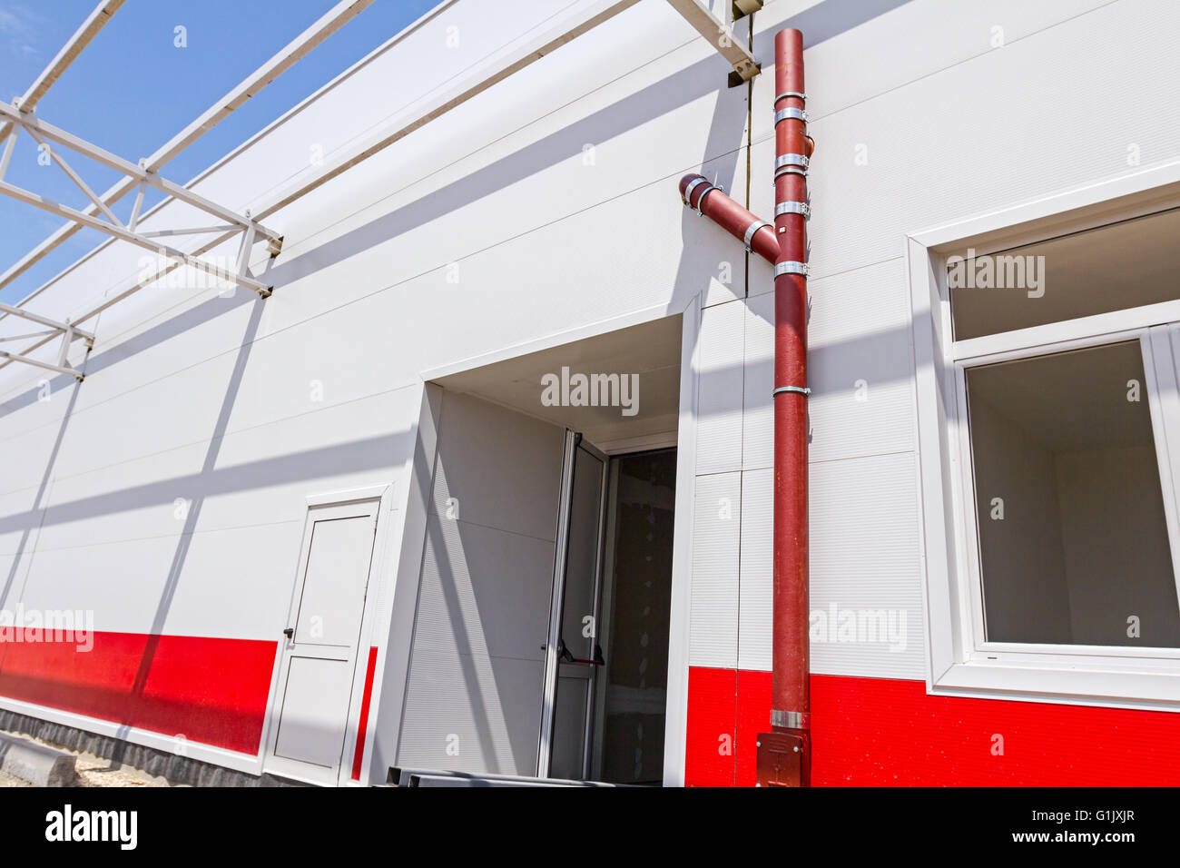 Unfinished red rain drain pipe for gutter on new building Stock Photo ...