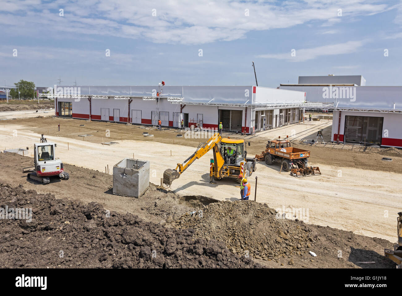 Backhoe tractor is working on a construction site, digging a pit Stock ...