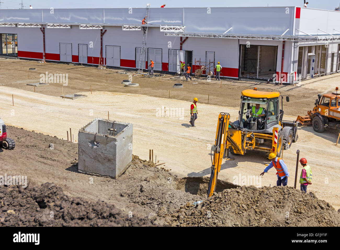 Backhoe tractor is working on a construction site, digging a pit Stock ...