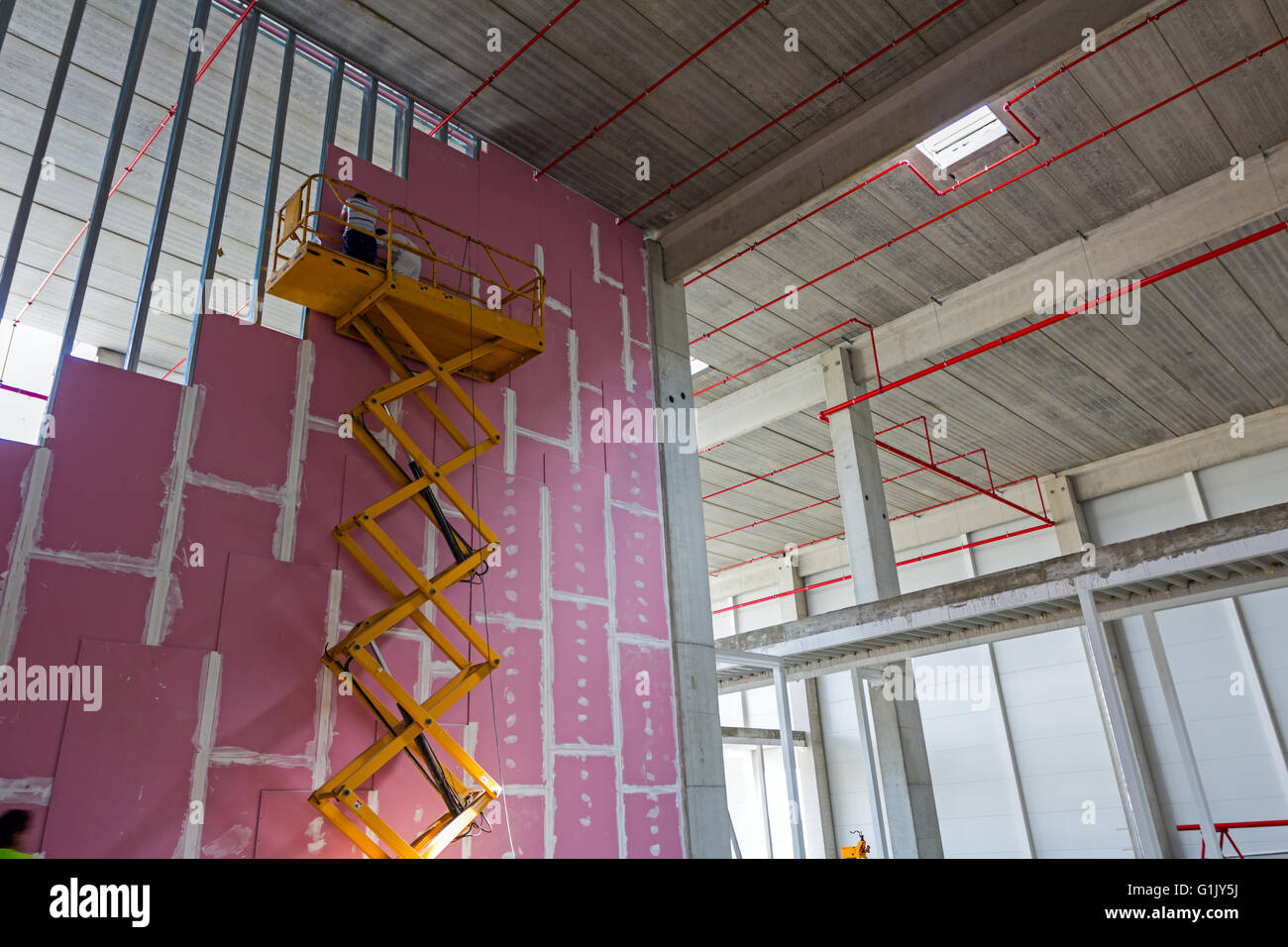 Workers are high up in cherry picker on building site Stock Photo - Alamy
