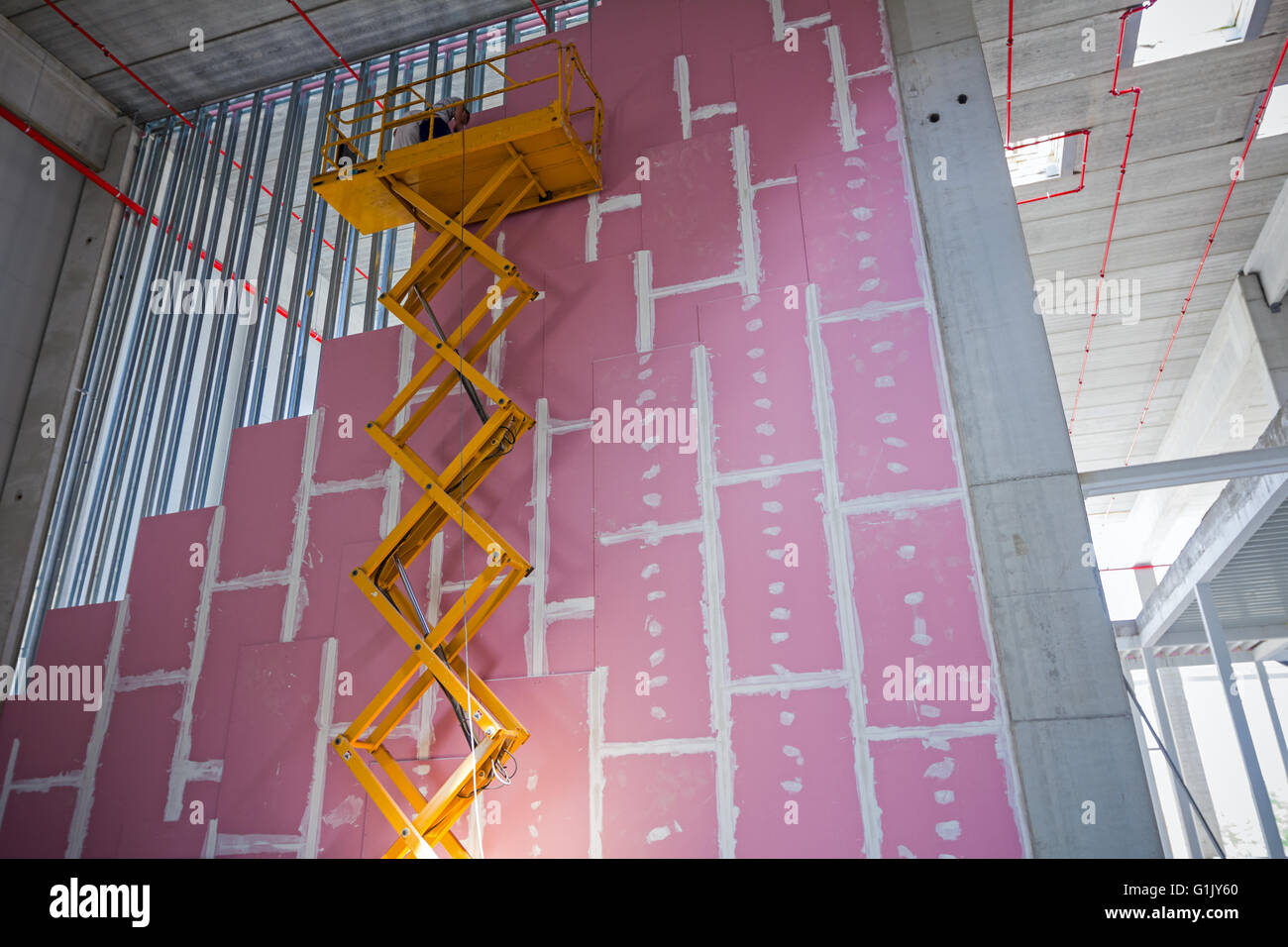 Workers are high up in cherry picker on building site Stock Photo - Alamy
