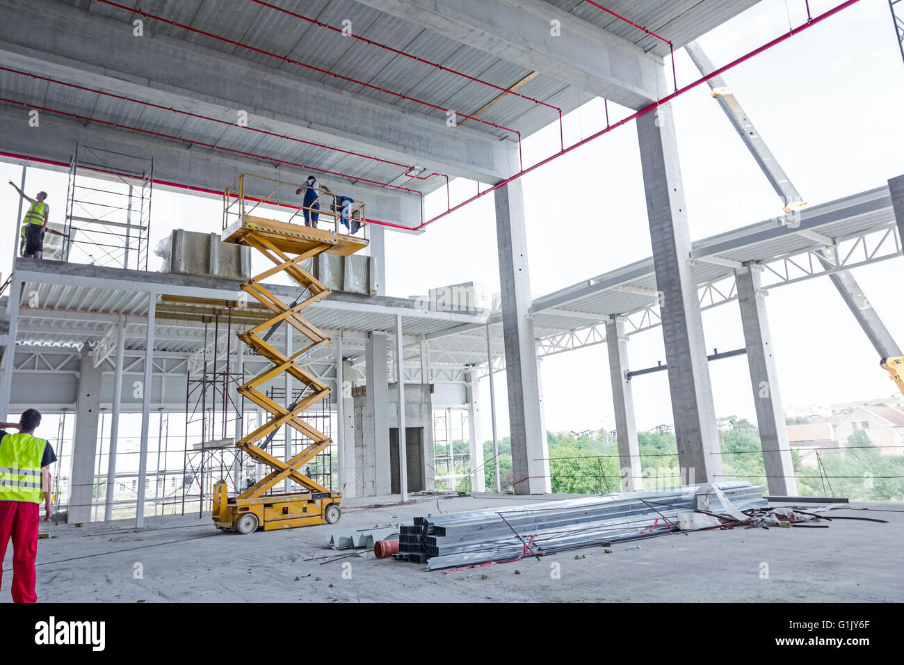 Workers are high up in cherry picker on building site Stock Photo - Alamy