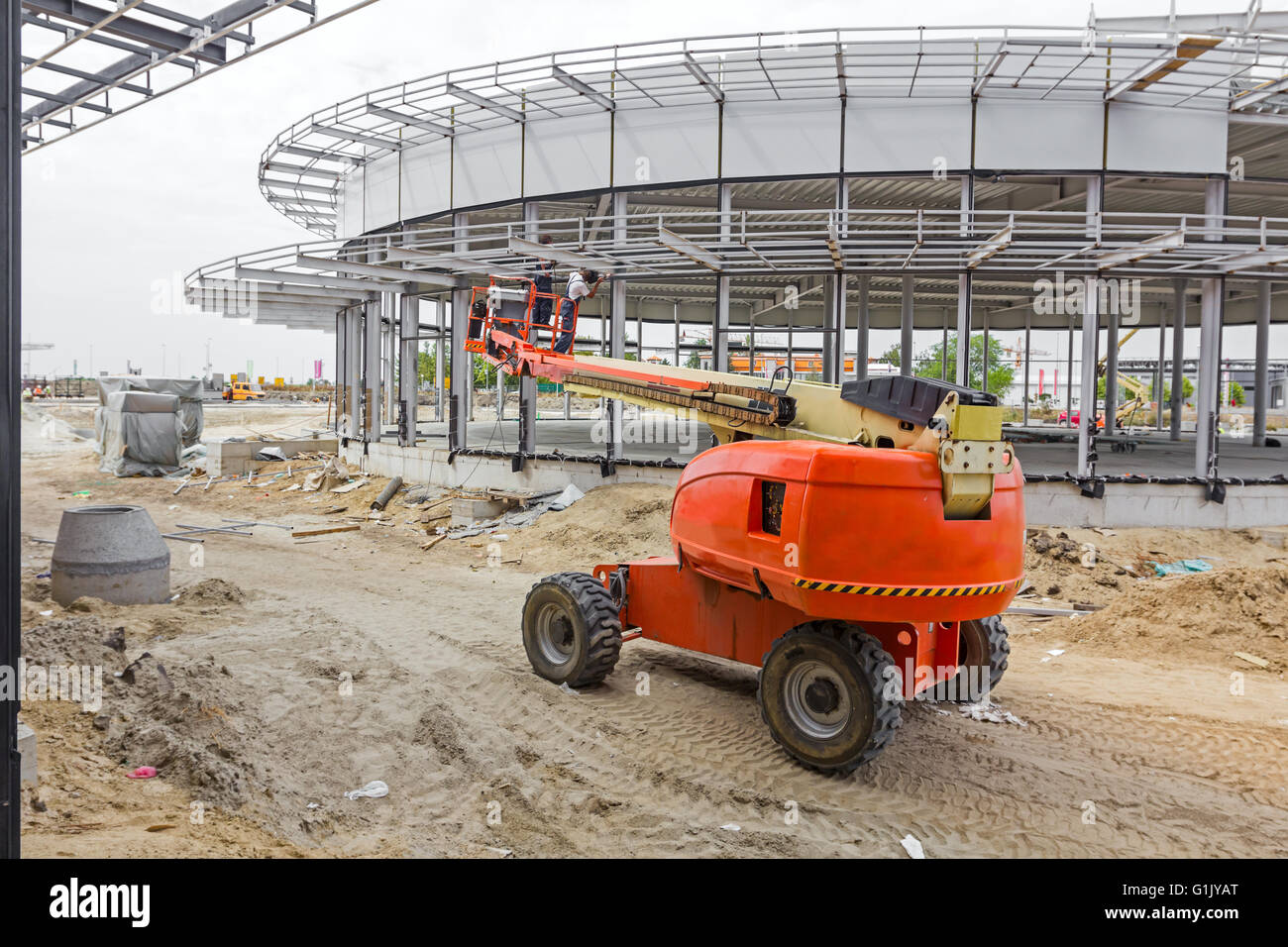 High elevated cherry picker with team of workers on construction site ...