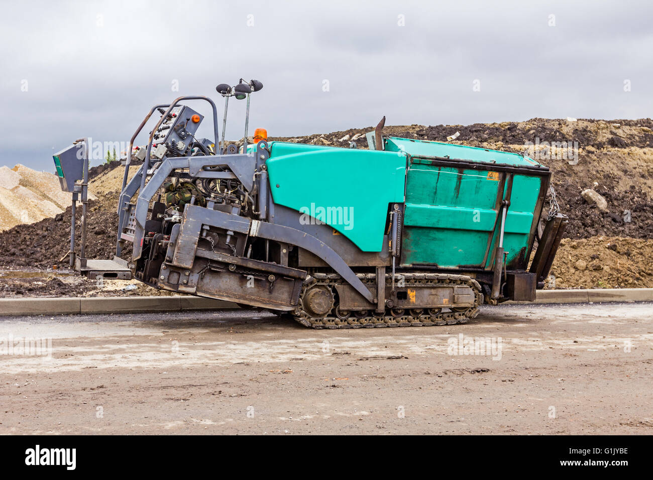 Side view on asphalt laying machine at construction site. Hot asphalt ...