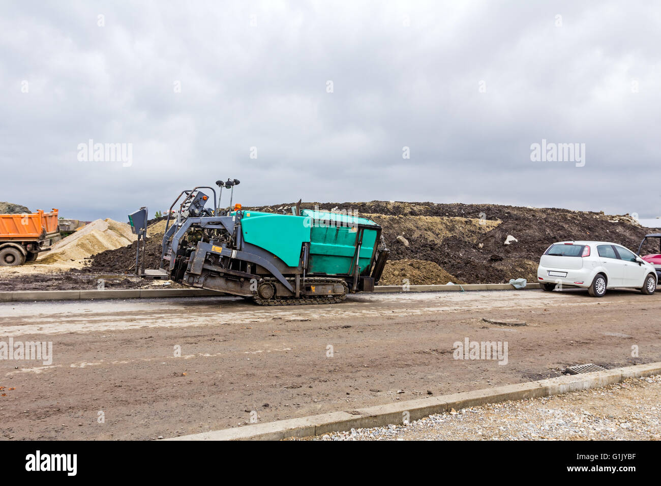 Side view on asphalt laying machine at construction site. Hot asphalt ...