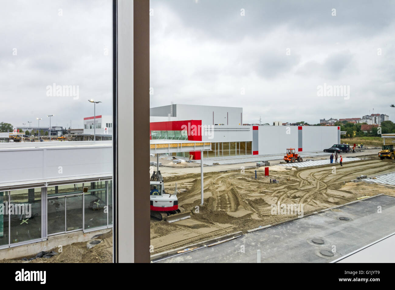 View through wide showcase on construction site with machinery, people ...