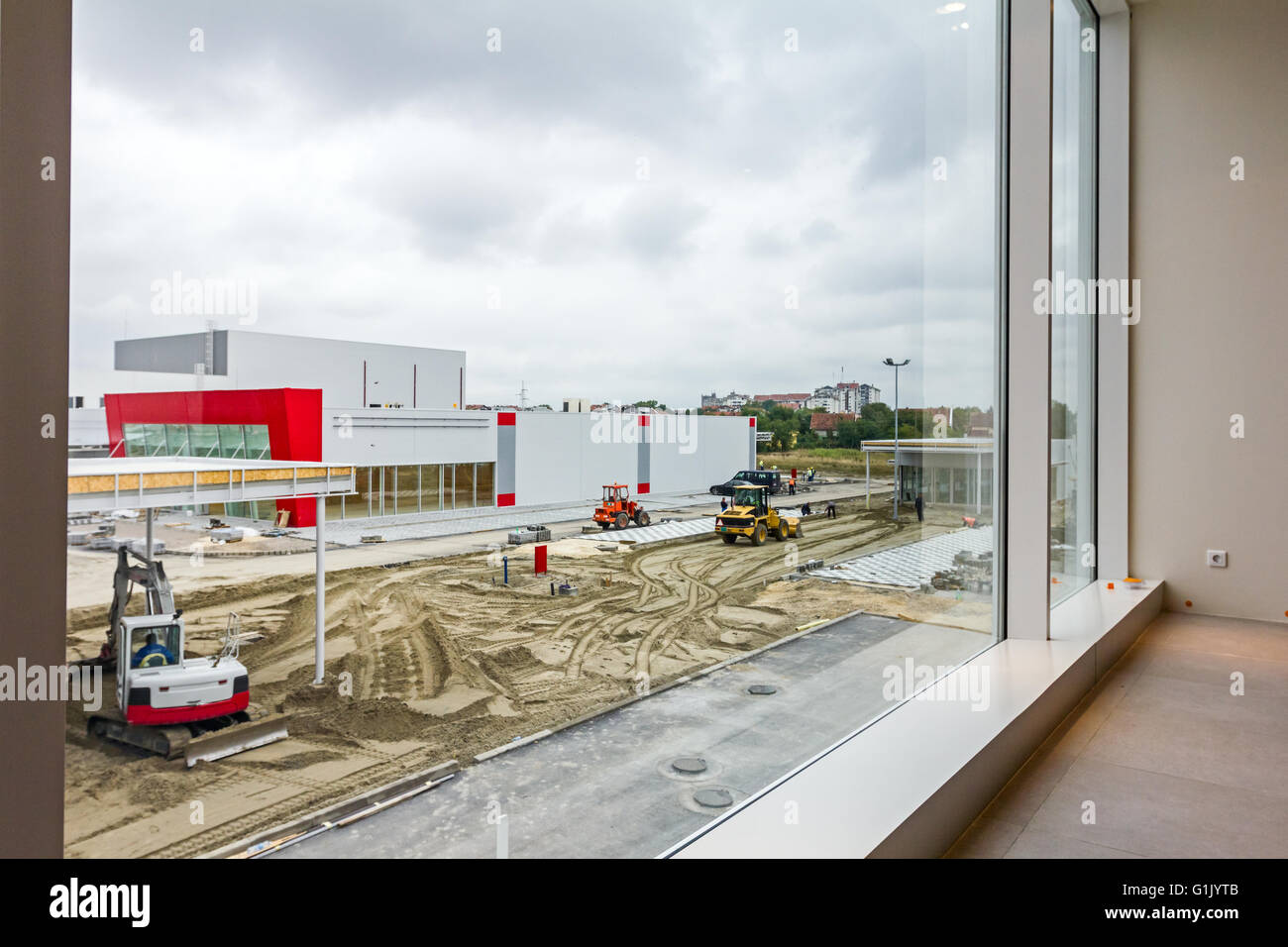 View through wide showcase on construction site with machinery, people ...