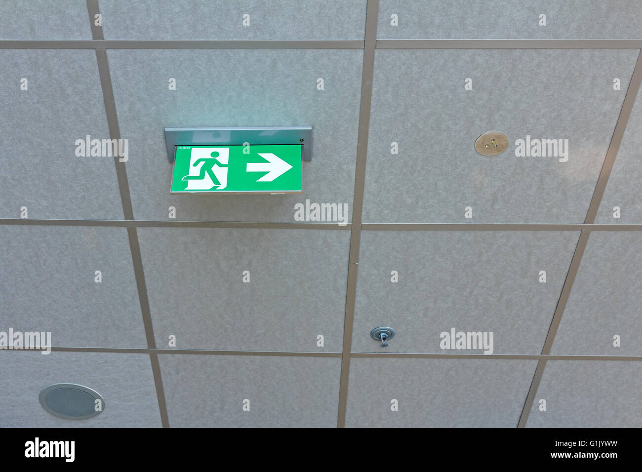 Standard international symbol safe exit sign is hanging from the ...