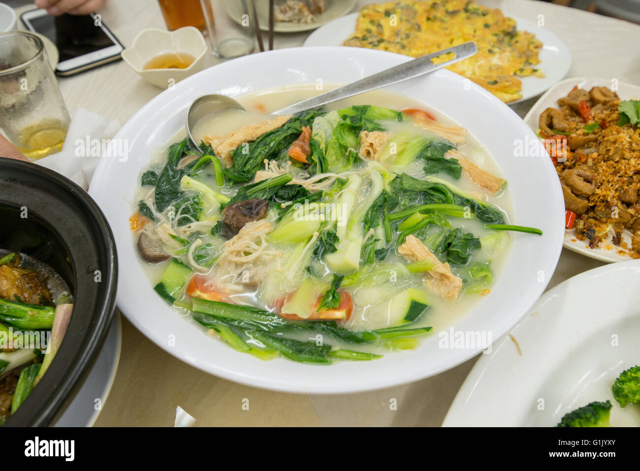 Large sharing bowl of Chinese Vegetable soup and spoon Stock Photo - Alamy