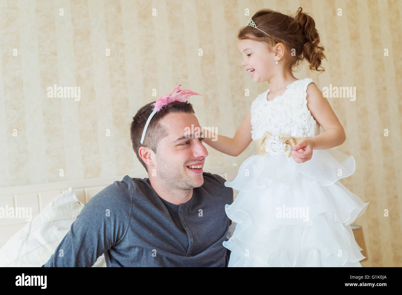 Cute girl putting a crown on her father head Stock Photo - Alamy