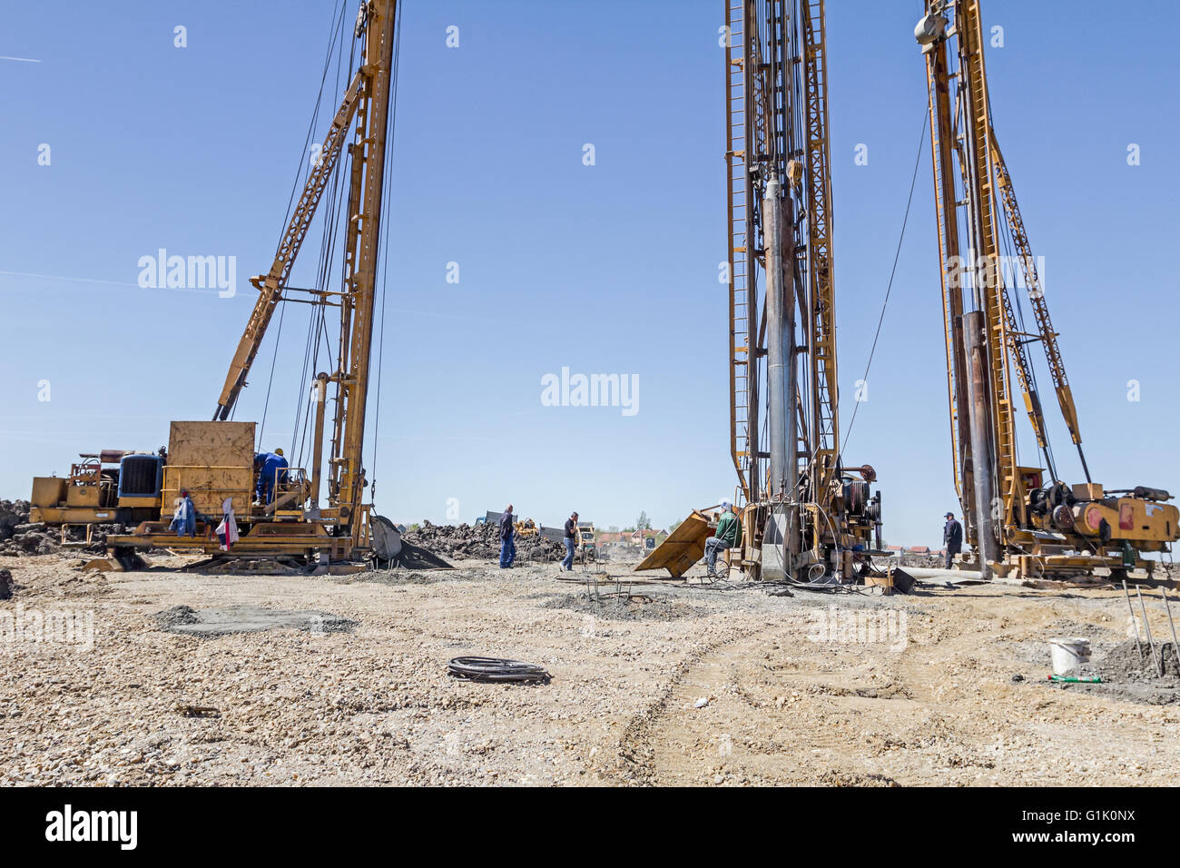 Workers are managing pile driving machines in construction site Stock ...