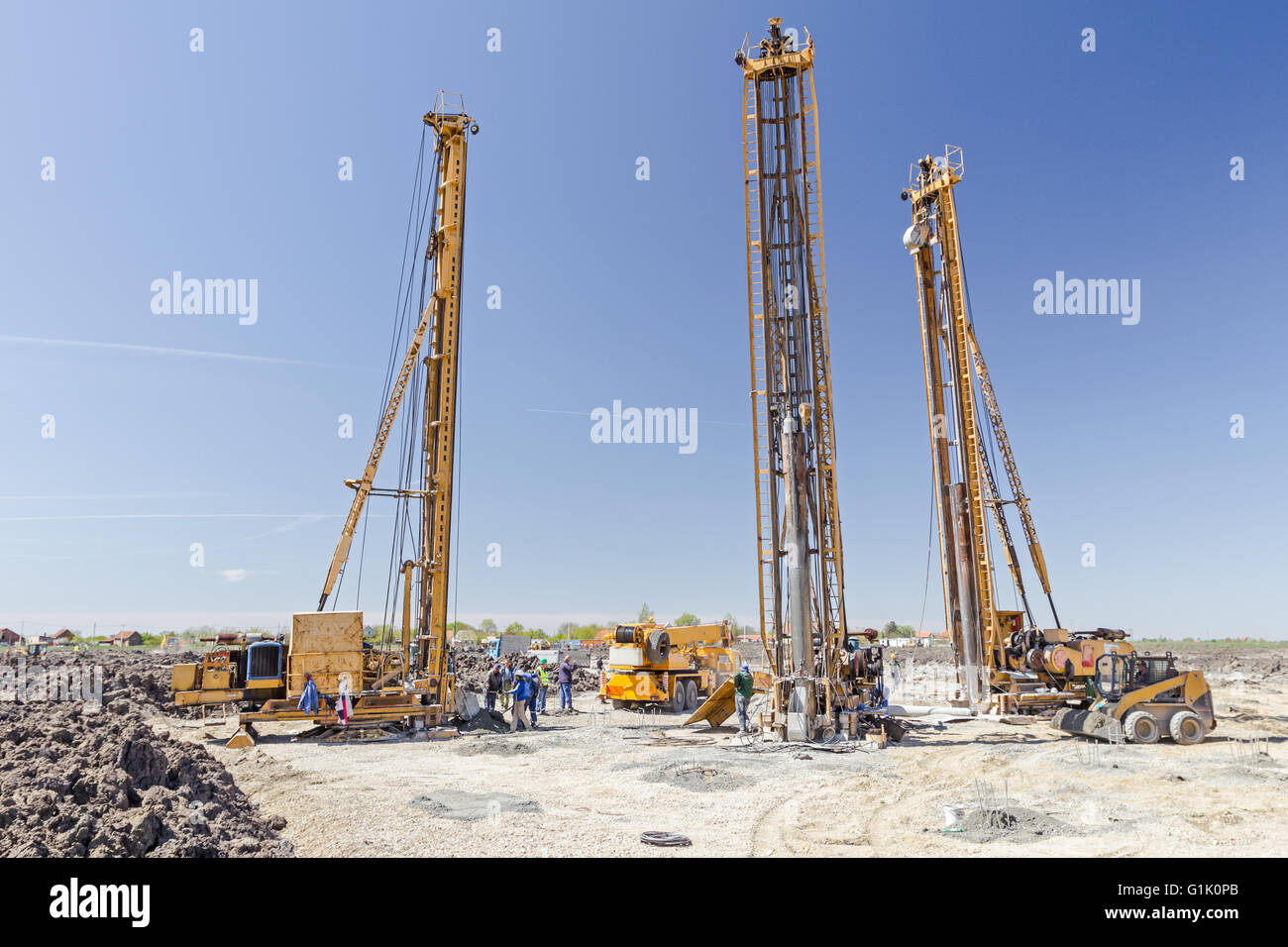 Workers are managing pile driving machines in construction site Stock ...