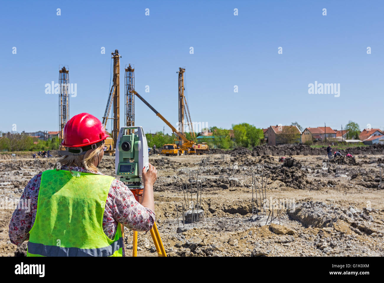 Woman surveying is measuring level on construction site. Surveyors ...