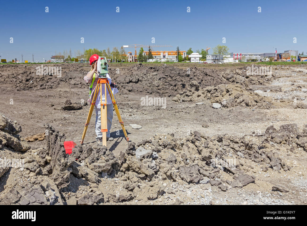 Woman surveying is measuring level on construction site. Surveyors ...