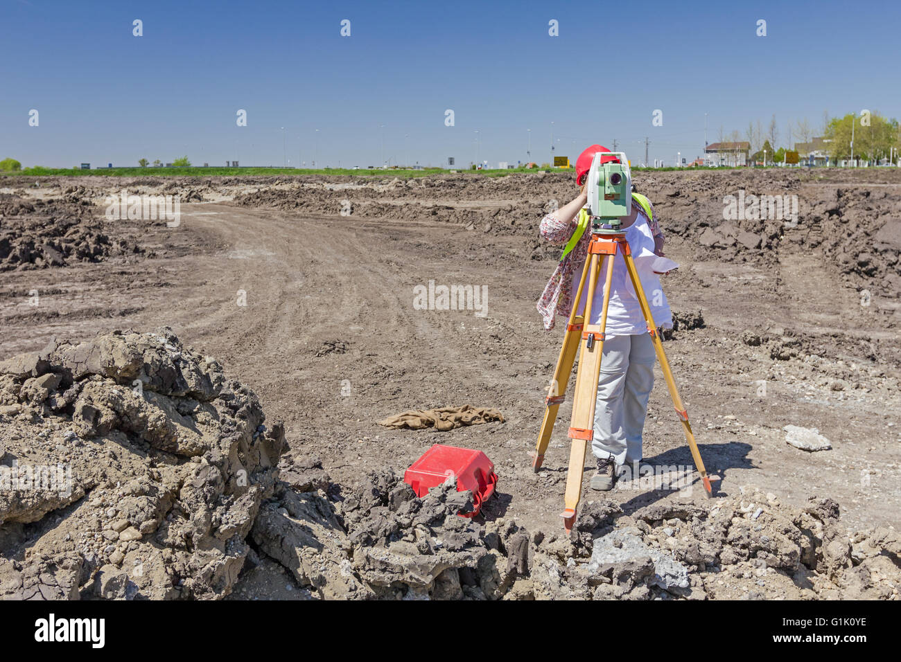 Woman surveying is measuring level on construction site. Surveyors ...