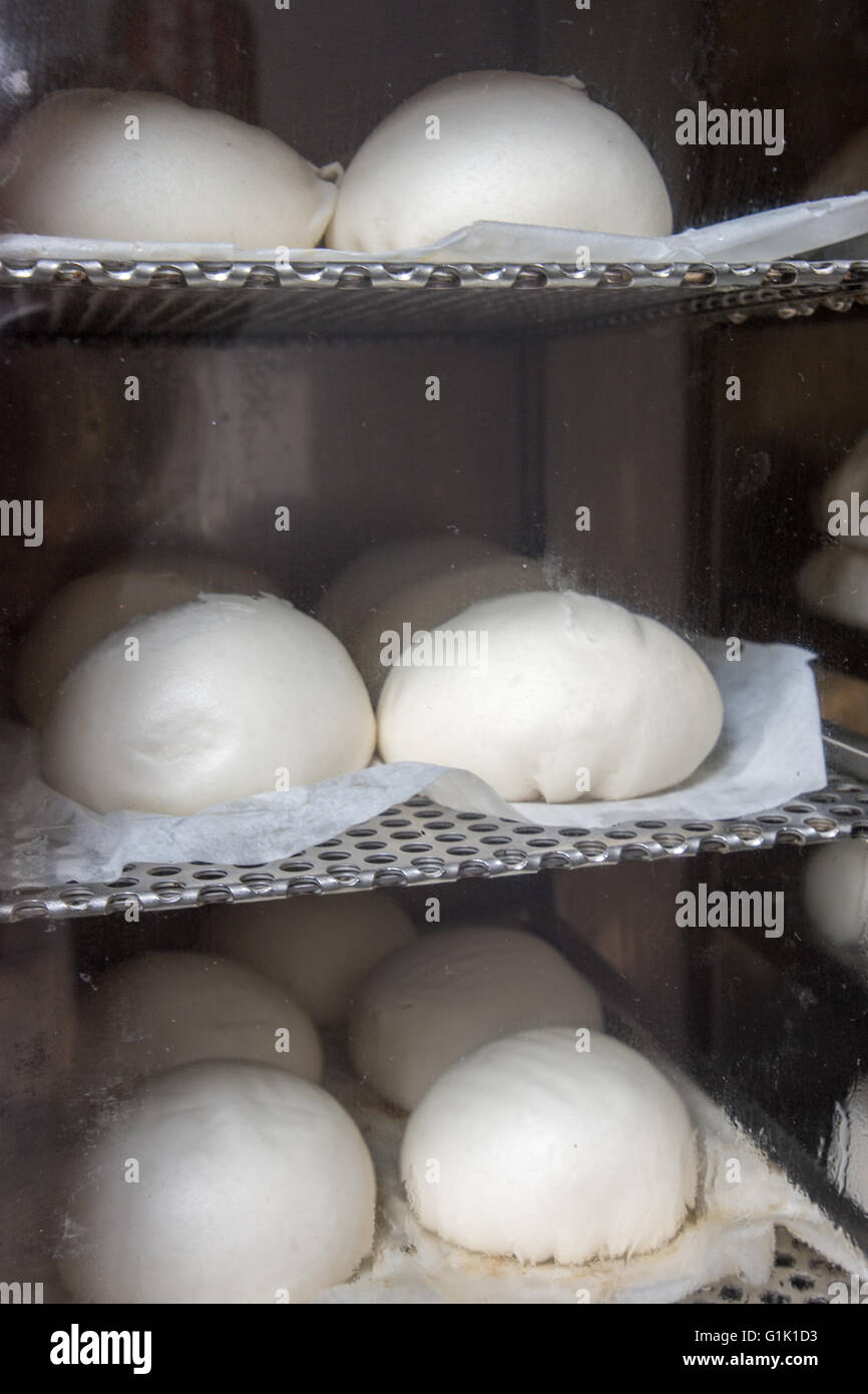 Large white soft breaded Chinese buns in oven through glass Stock Photo ...