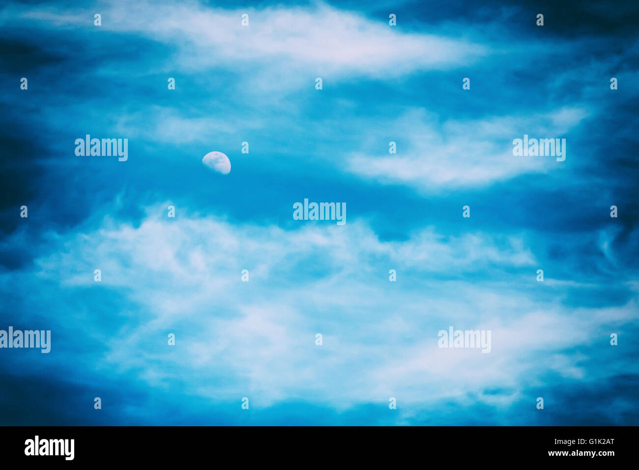 Moon Visible In Blue Sky With White Soft Clouds Stock Photo - Alamy