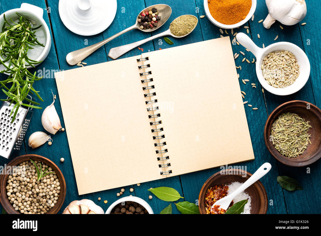 culinary background and recipe book with various spices on wooden table ...