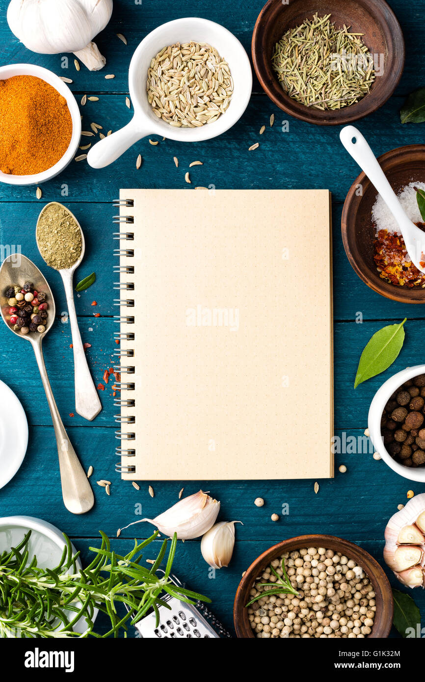 culinary background and recipe book with various spices on wooden table ...