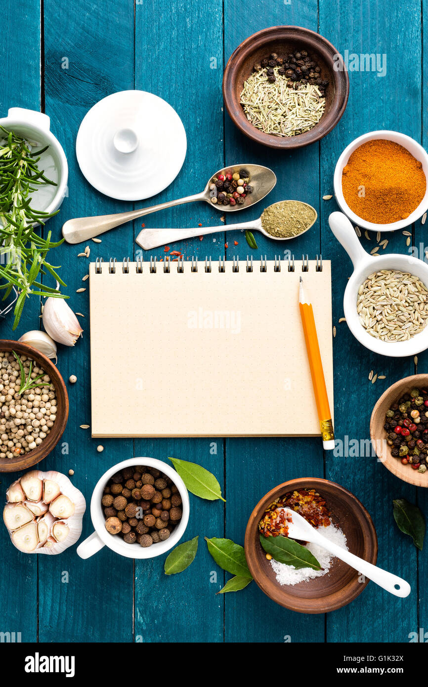 culinary background and recipe book with various spices on wooden table ...