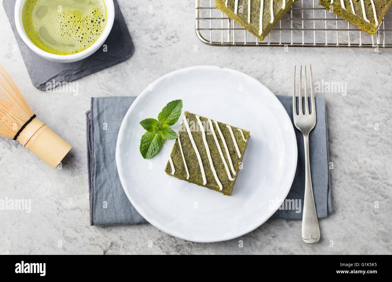 Matcha green tea brownie cake with white chocolate on a white plate ...