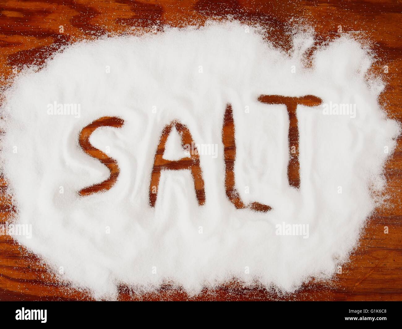Salt spilled on wooden table Stock Photo - Alamy