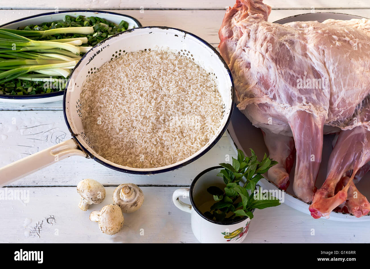 Preparing the sacrificial whole raw lamb for Easter in tray with rice ...