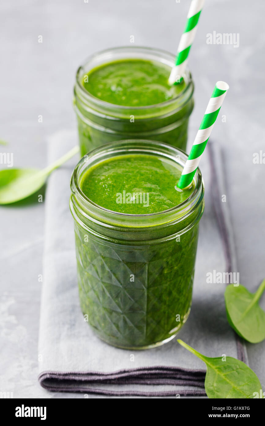 Spinach smoothie Healthy drink in glass jar on grey stone background ...