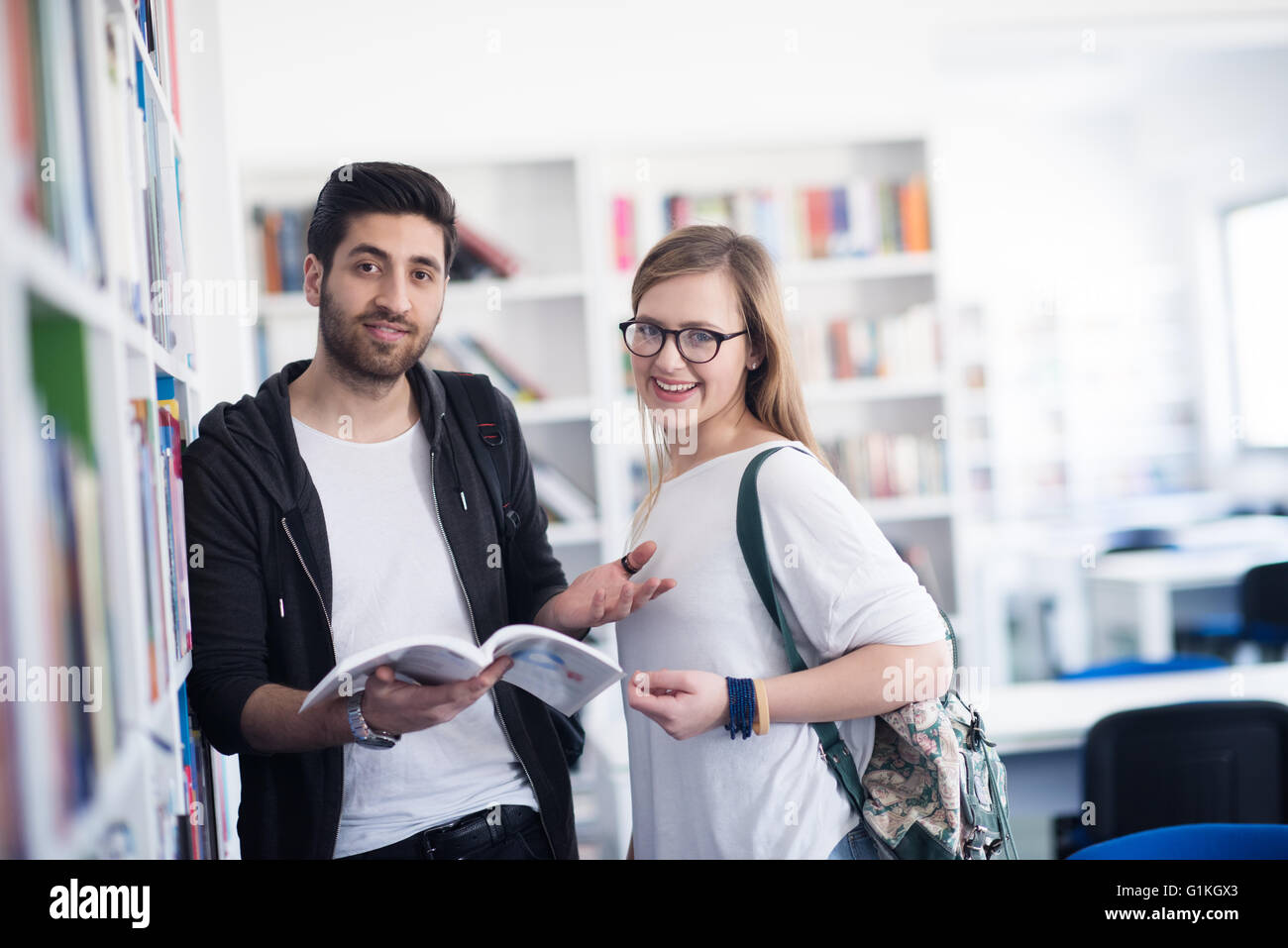 happy students couple in school library have discussion about book ...