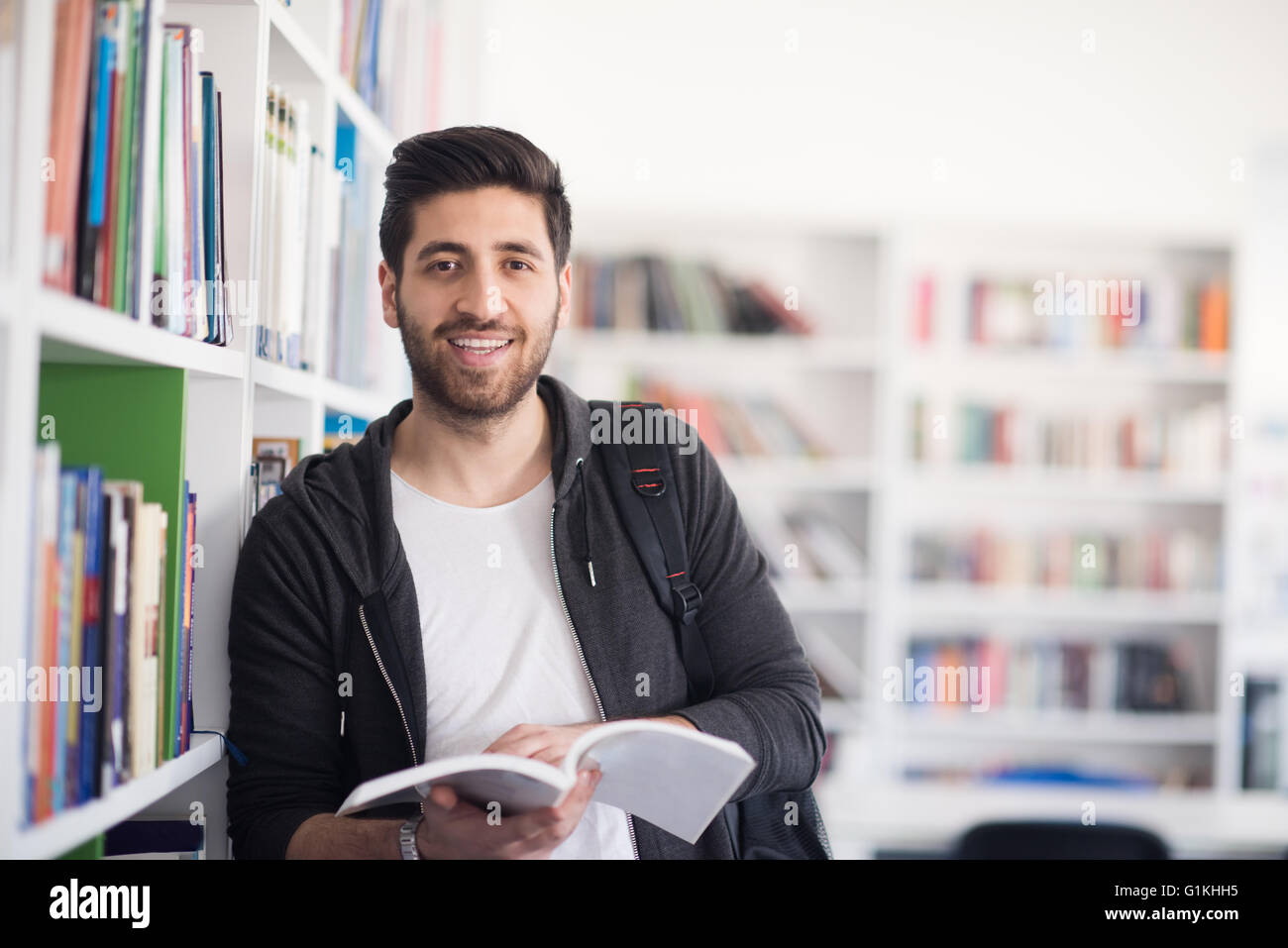 Portrait of happy student while reading book in school library. Study ...