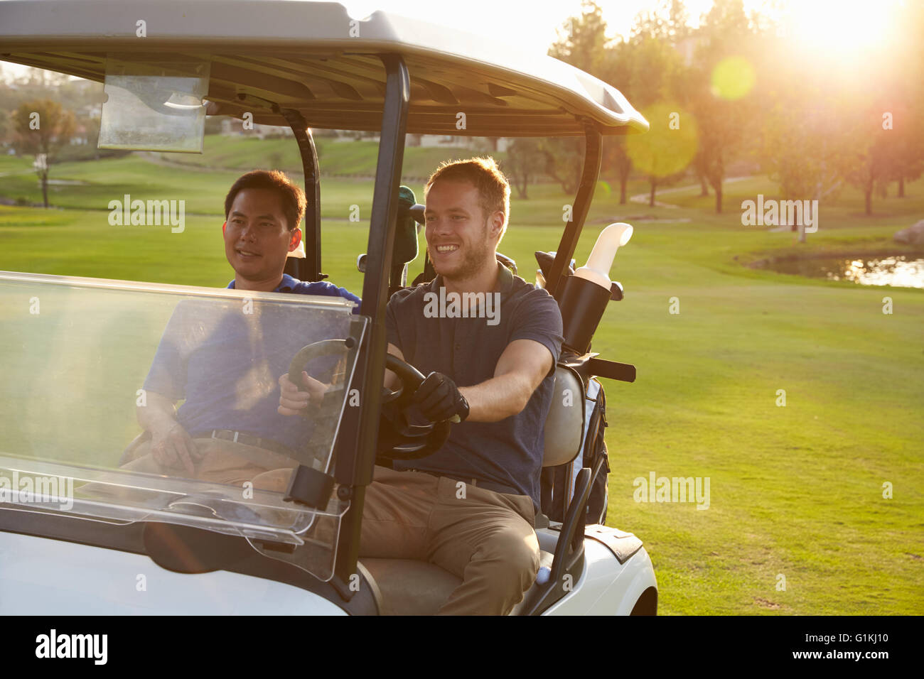 Male Golfers Driving Buggy Along Fairway Of Golf Course Stock Photo - Alamy