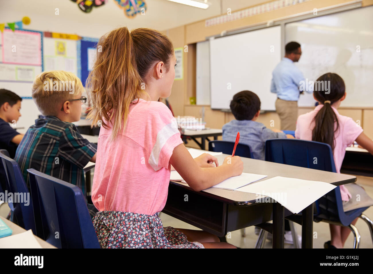 Teacher writing on the board in an elementary school class Stock Photo ...