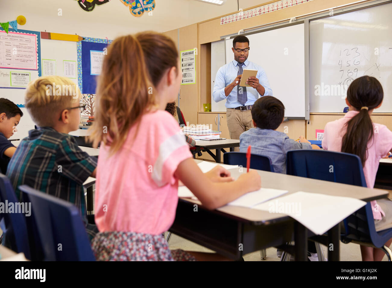 Teacher using tablet computer in an elementary school class Stock Photo ...