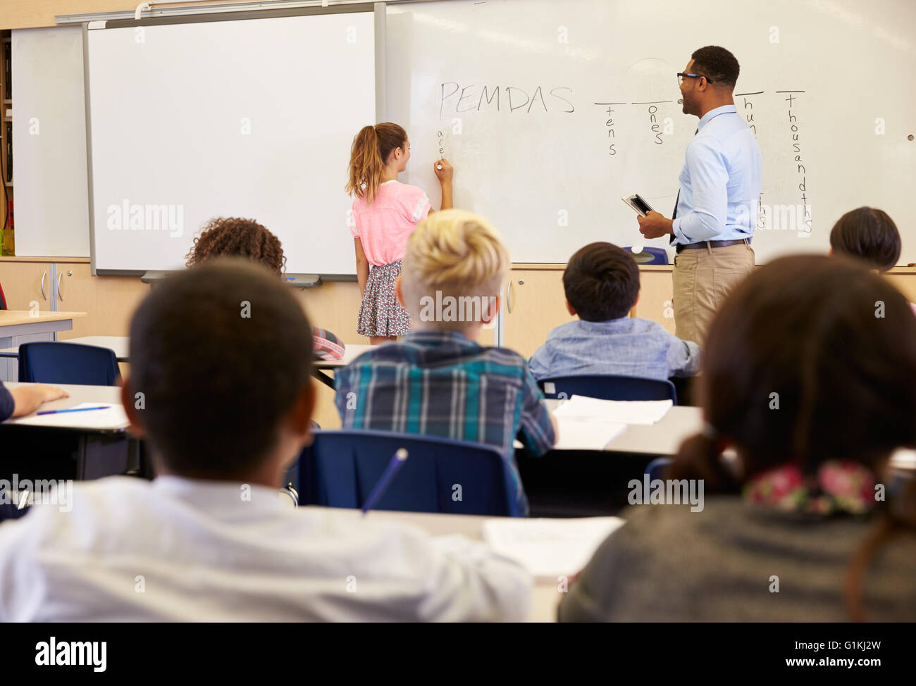 Pupil writing on the board in an elementary school lesson Stock Photo ...
