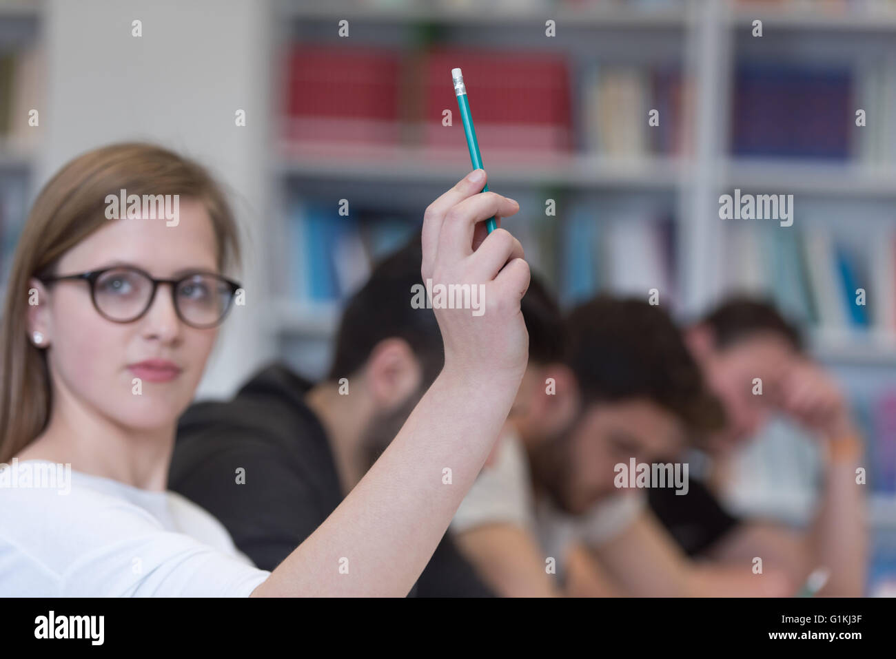 group of smart students raise hands up in school classroom on class ...