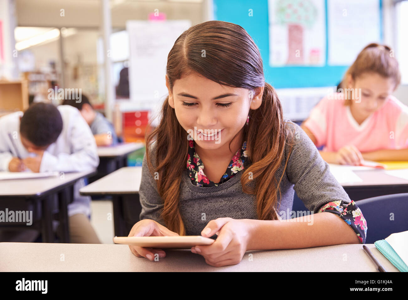 School girl using tablet computer in elementary school class Stock ...