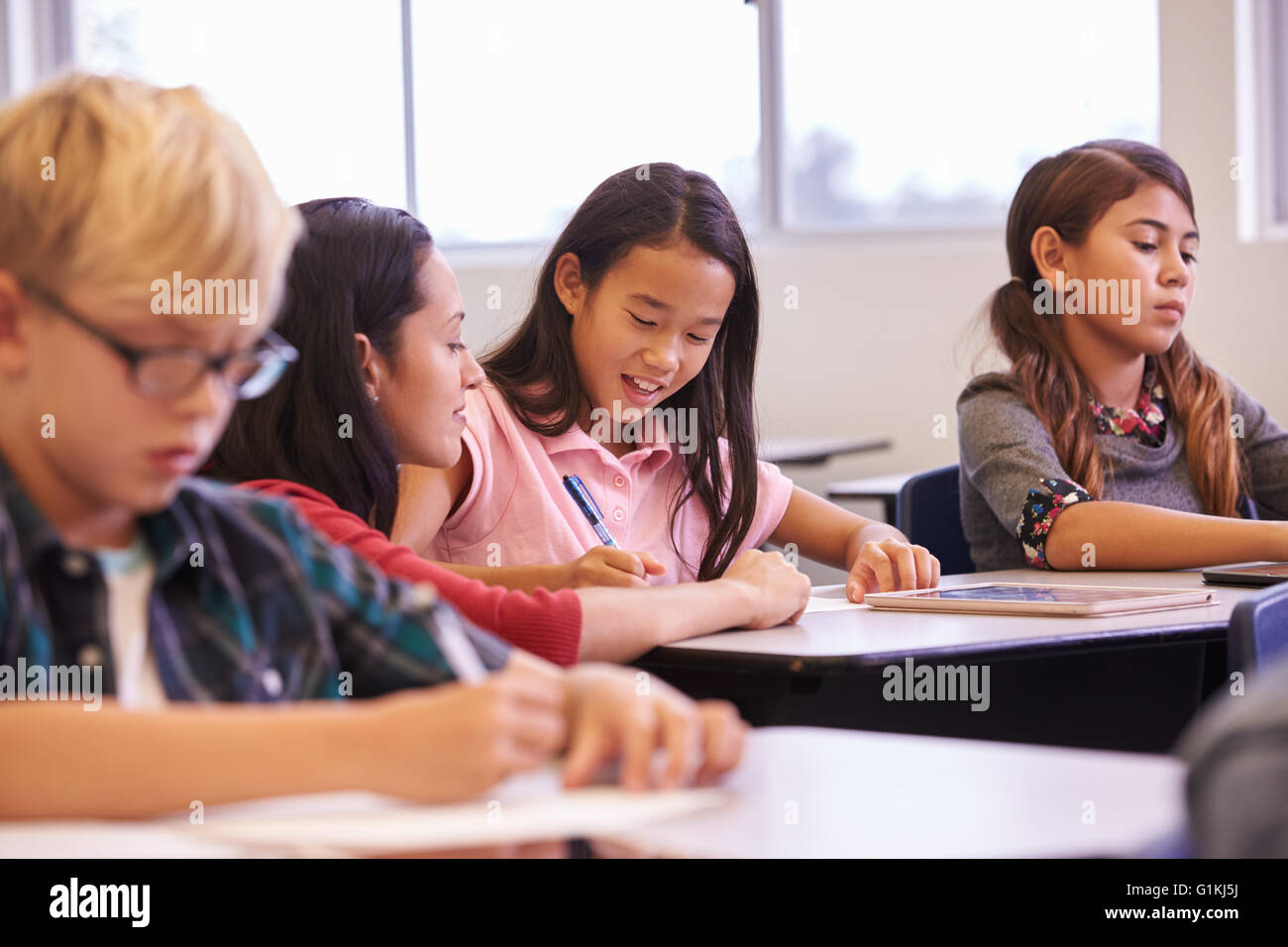Elementary school kids working at their desks in a classroom Stock ...