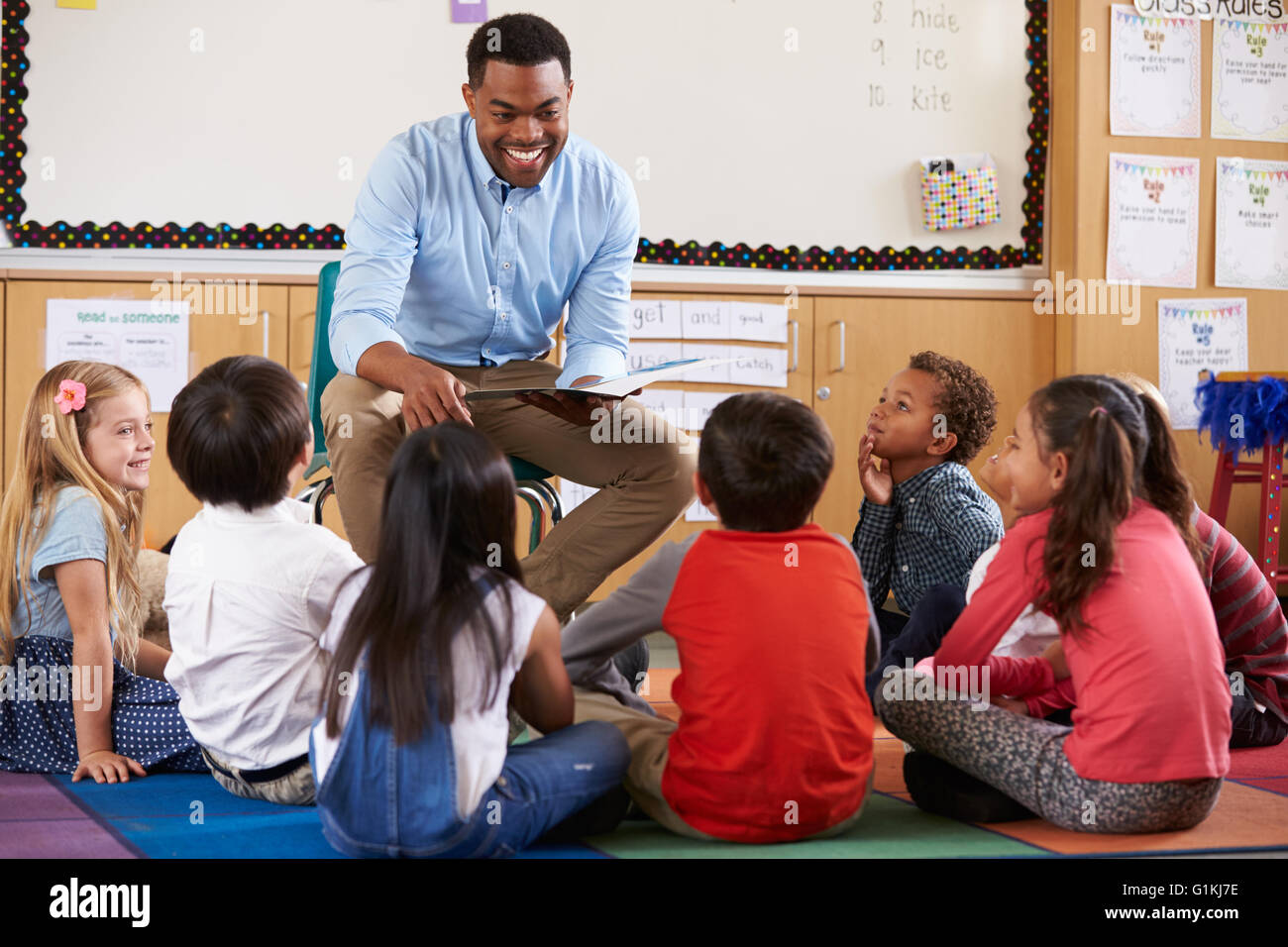 Kids sitting around teacher hi-res stock photography and images - Alamy