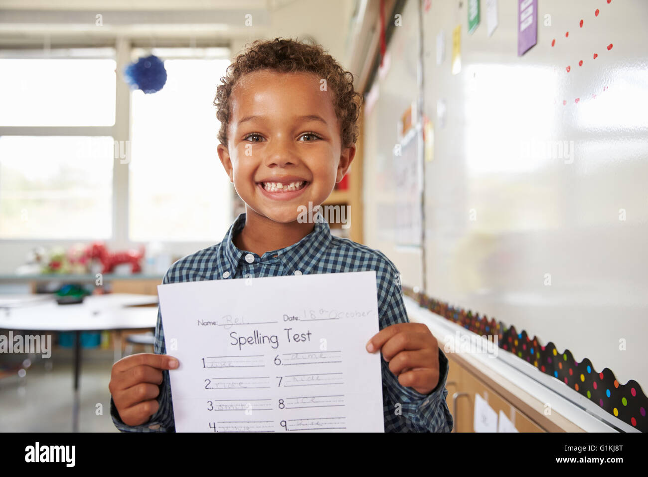 Portrait of elementary school boy holding up his test paper Stock Photo ...