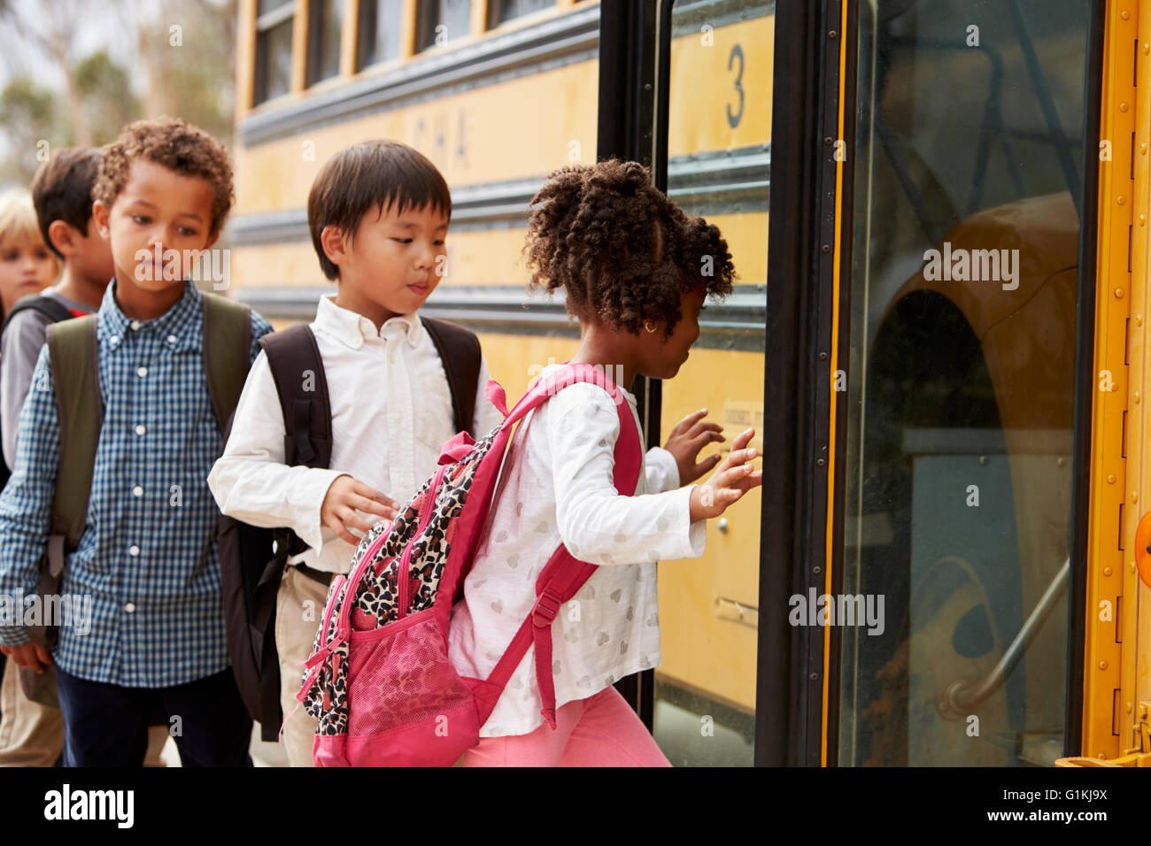 Elementary school kids climbing on to a school bus Stock Photo - Alamy