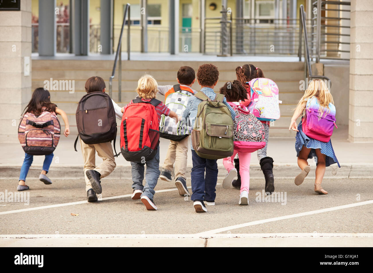 Elementary school kids running into school, back view Stock Photo - Alamy