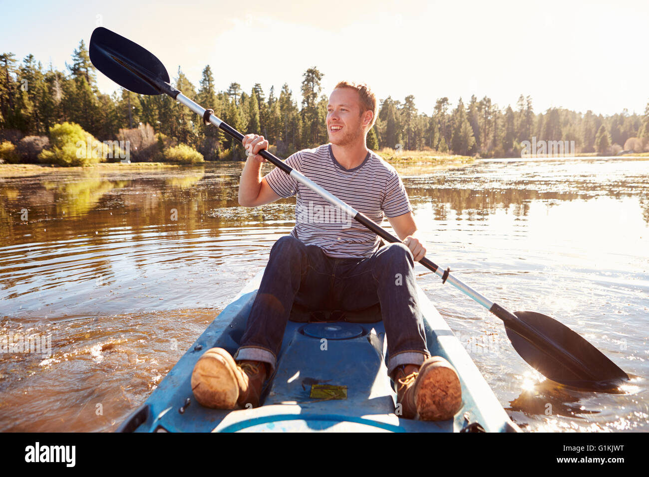 Young Man Rowing Kayak On Lake Stock Photo - Alamy
