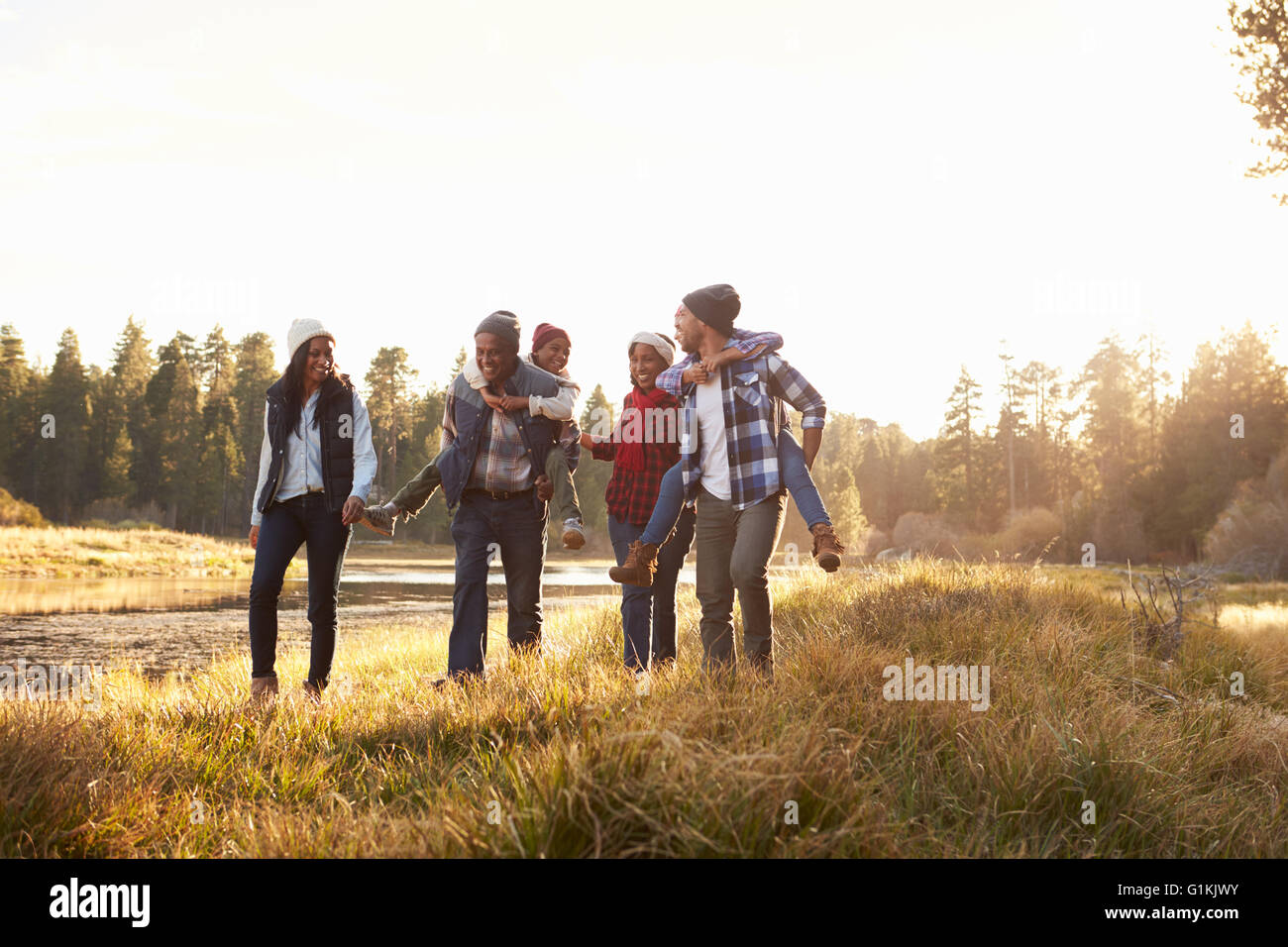 Extended Family Group Walking By Lake Stock Photo - Alamy