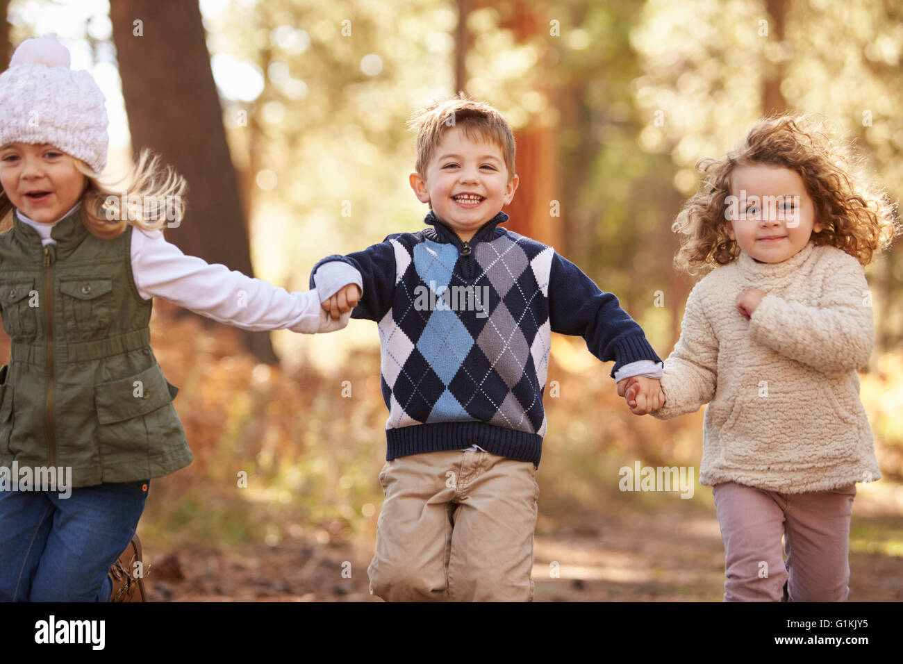 Group Of Young Children Running Along Path In Autumn Forest Stock Photo ...