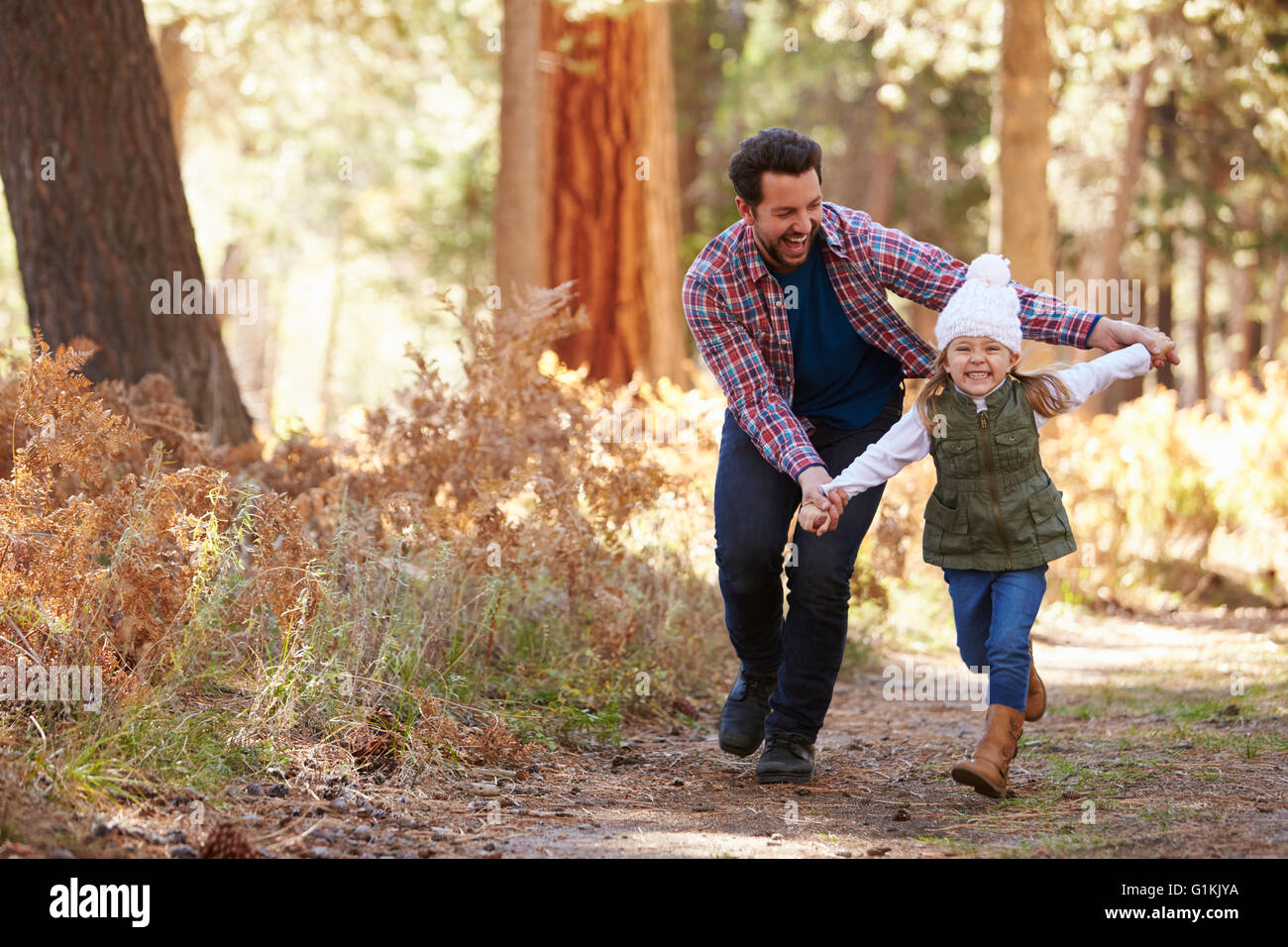 Father And Daughter Running Through Fall Woodland Stock Photo - Alamy