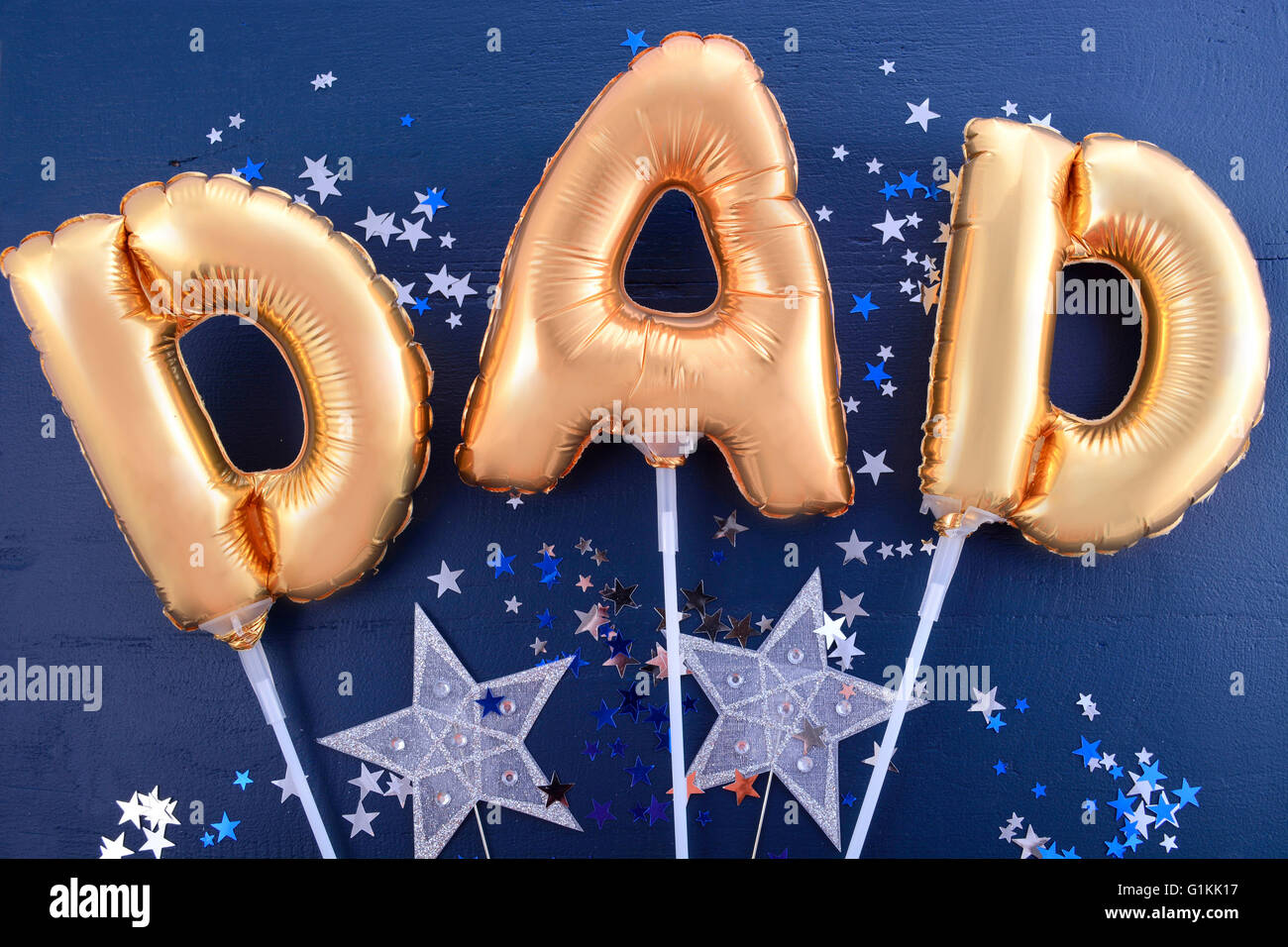 Happy Fathers Day gold baloons for the word, Dad, on dark blue wood ...