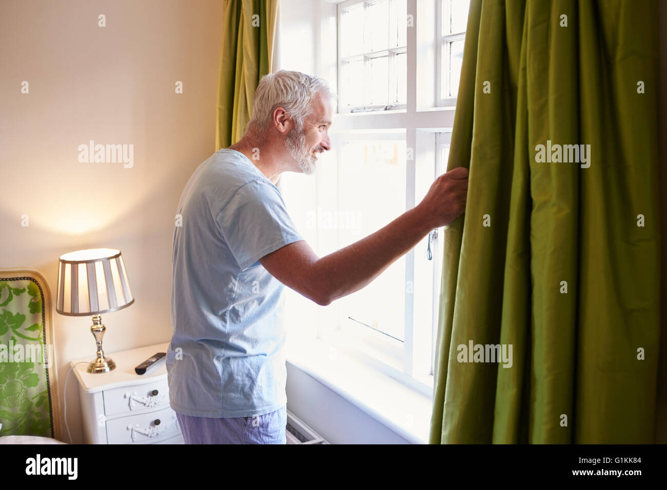Man opening curtains in the morning hi-res stock photography and images ...