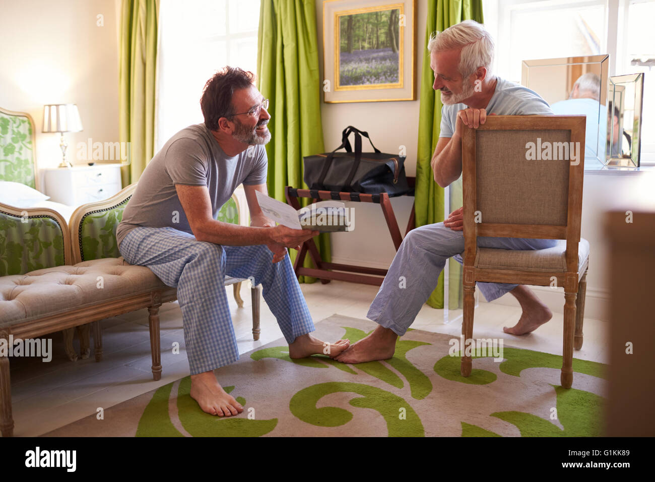 Male couple wearing pyjamas in a hotel room plan their day Stock Photo ...