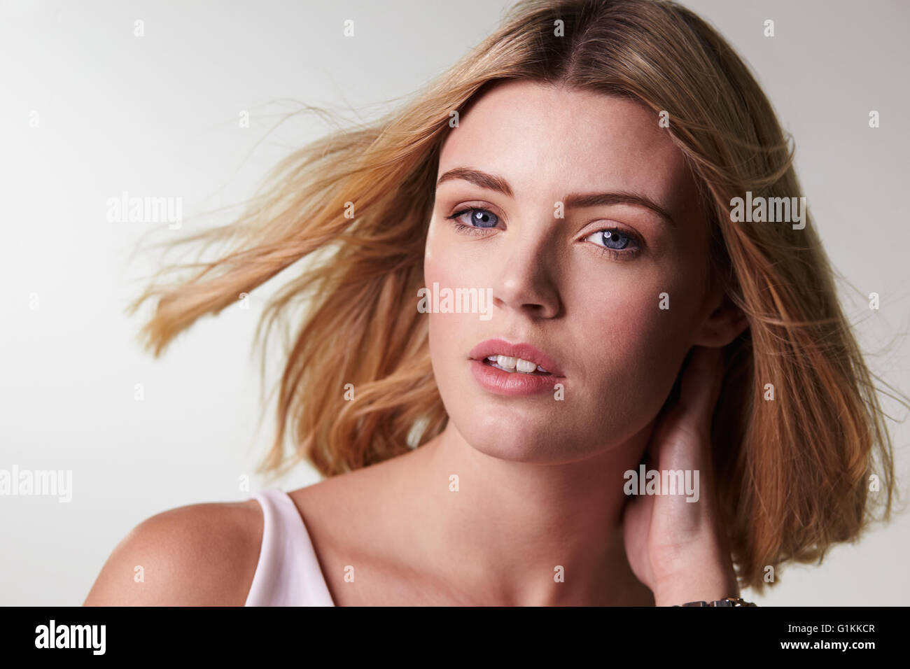 Blonde woman looking at camera, hair blowing, horizontal Stock Photo ...