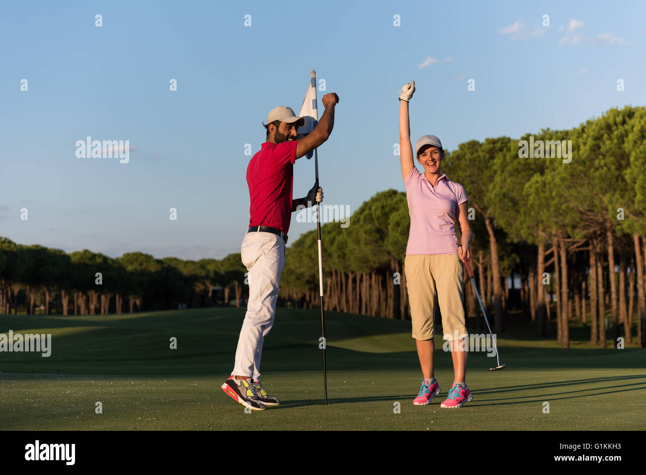 male golf instructor teaching female golf player, personal trainer ...